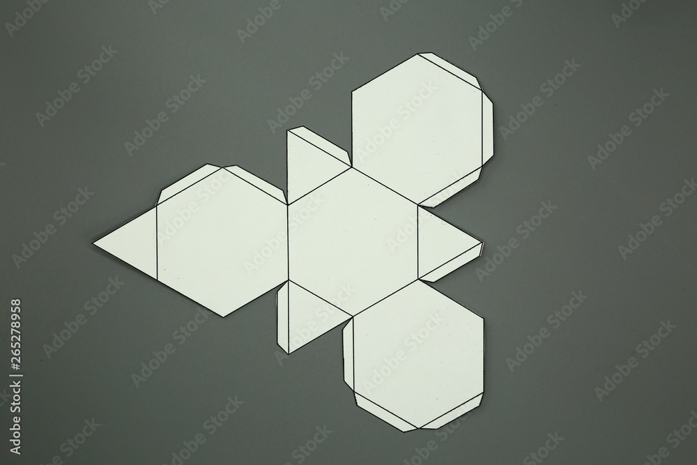 Geometric shape cut out of paper and photographed from above on grey ...