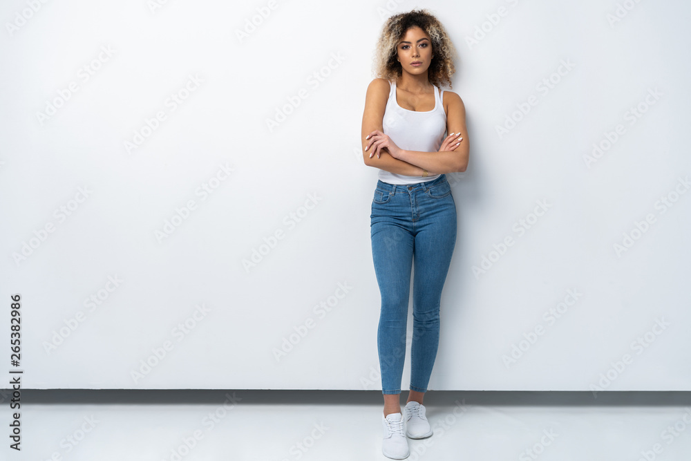 Full length portrait of stylish young black woman standing on white ...