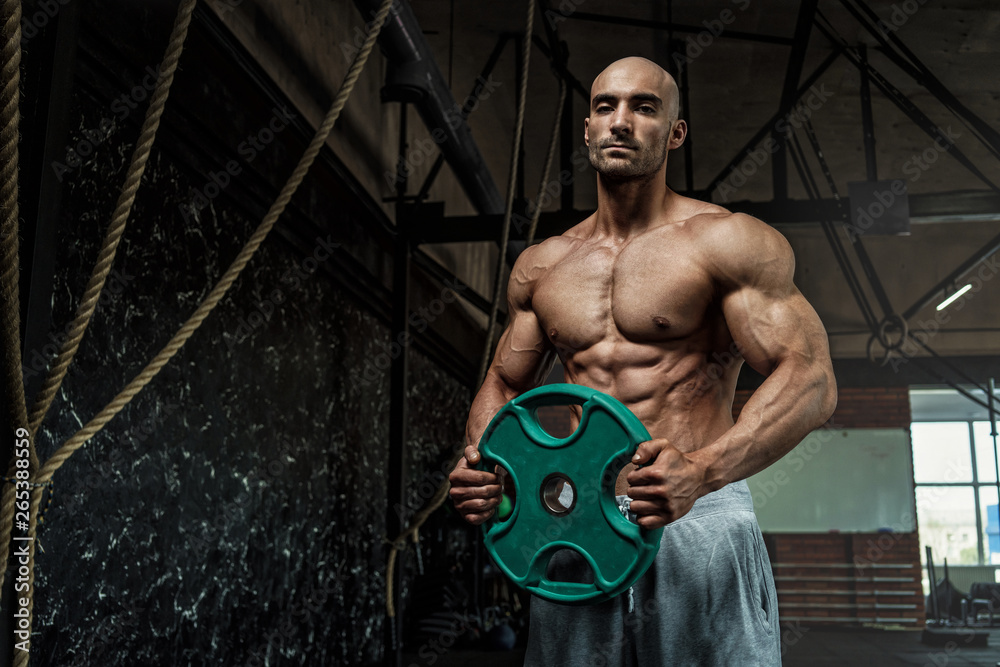 Young handsome sportsman bodybuilder weightlifter with an ideal body ...