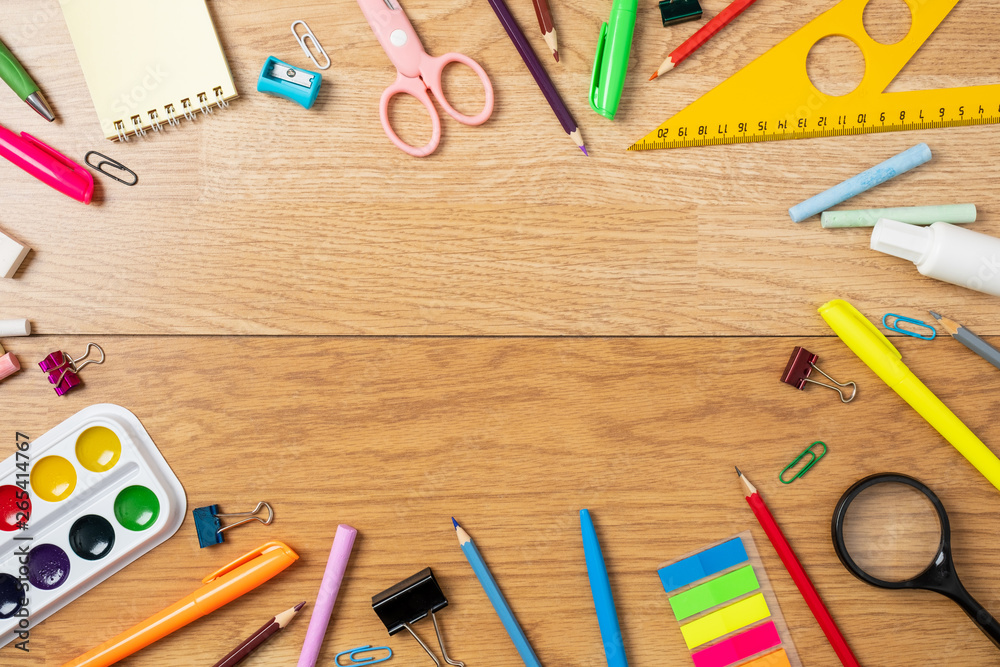 School supplies on wooden table, background with frame made of ...