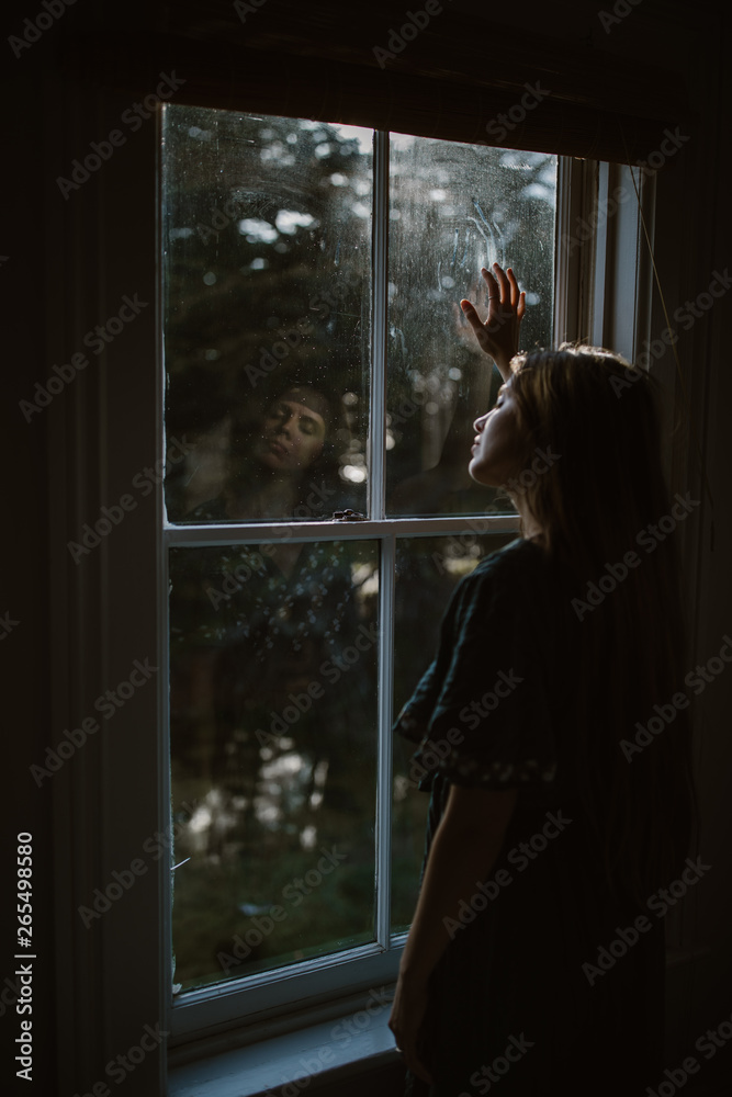 sad woman looking out window in home Stock Photo | Adobe Stock