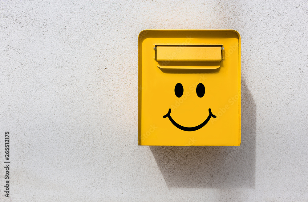 Yellow mailbox on white wall with smiley face on it. Positive vibes ...