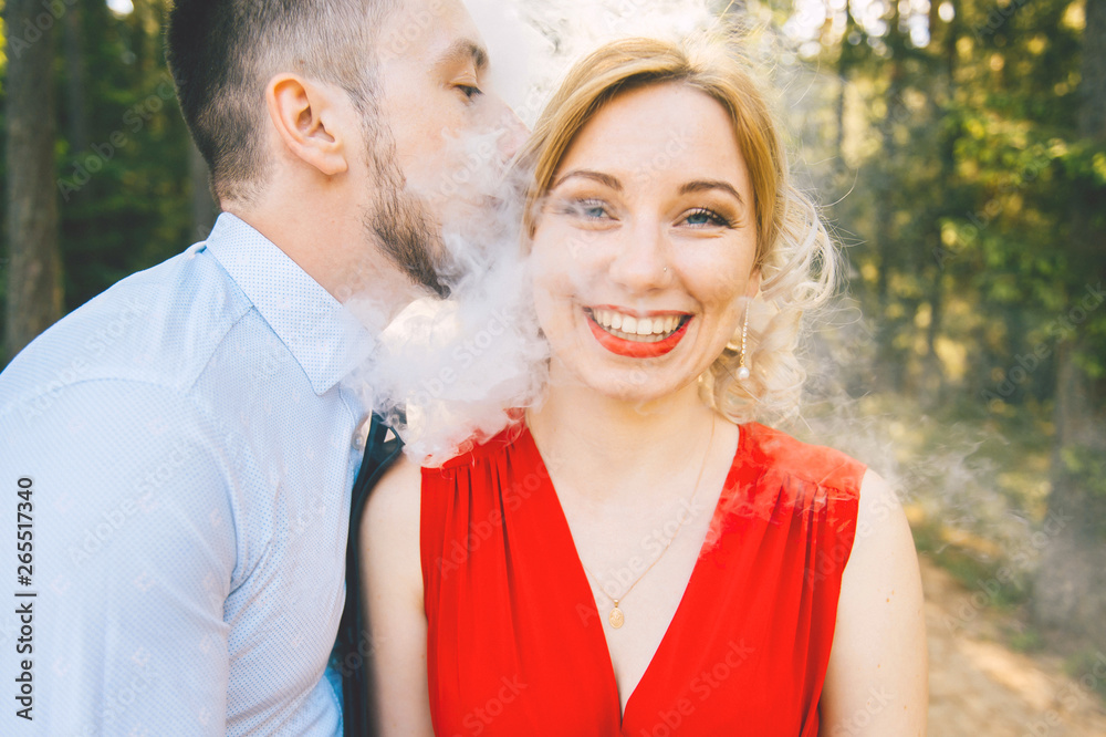 Smoking man in business clothes kissing young blonde girl with red lips ...