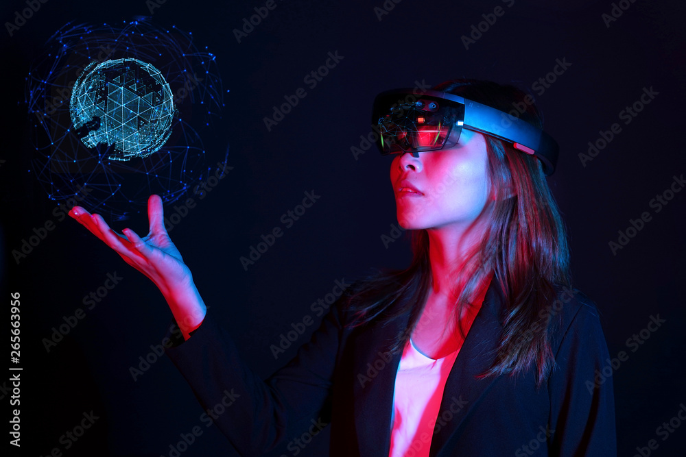 Business woman try vr glasses hololens in the dark room. Young asian ...