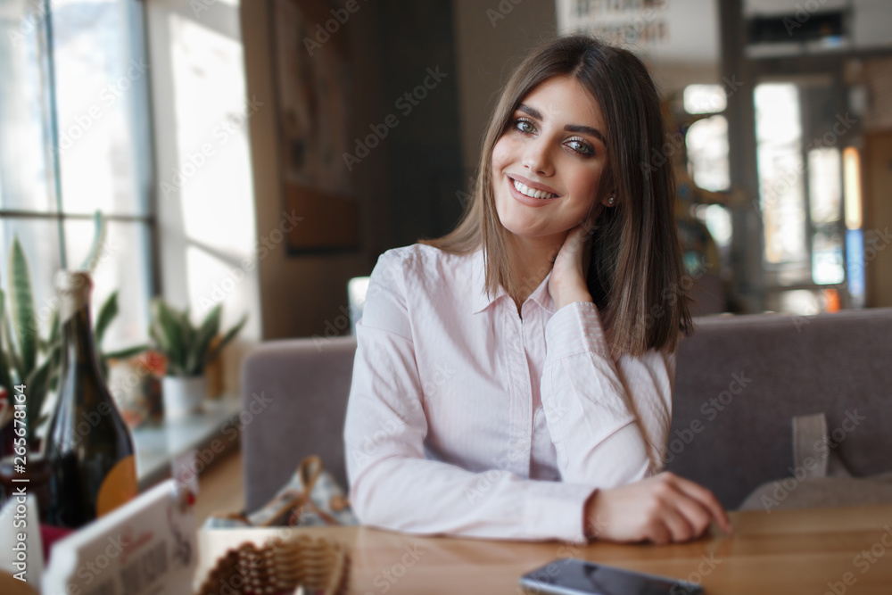 Beautiful woman at a table in a cafe.Young beautiful woman, brunette ...