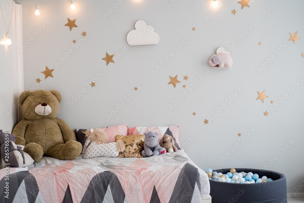 Teddy bear between paper bags and wooden chairs in child's room with ...
