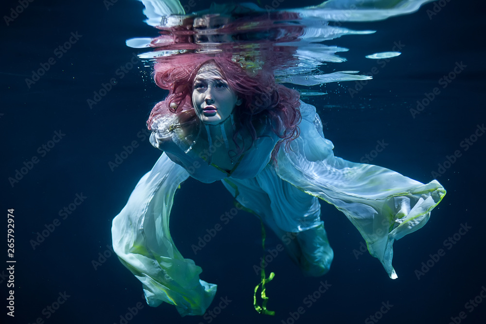 woman with pink hair in white dress underwater. Mermaid, nymph or ...
