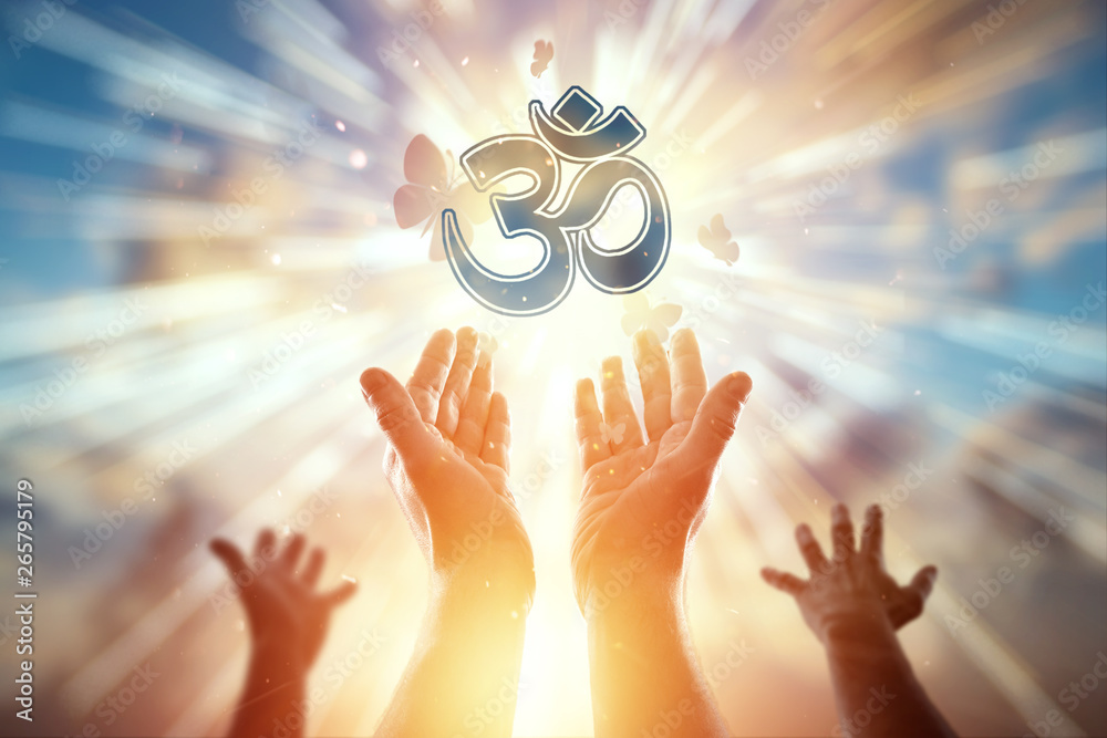 Hands closeup on the background of the symbol of Hinduism, prayer. The ...