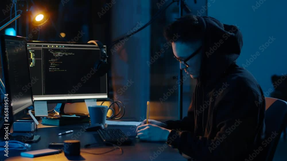 cybercrime, hacking and technology concept - asian male hacker in ...