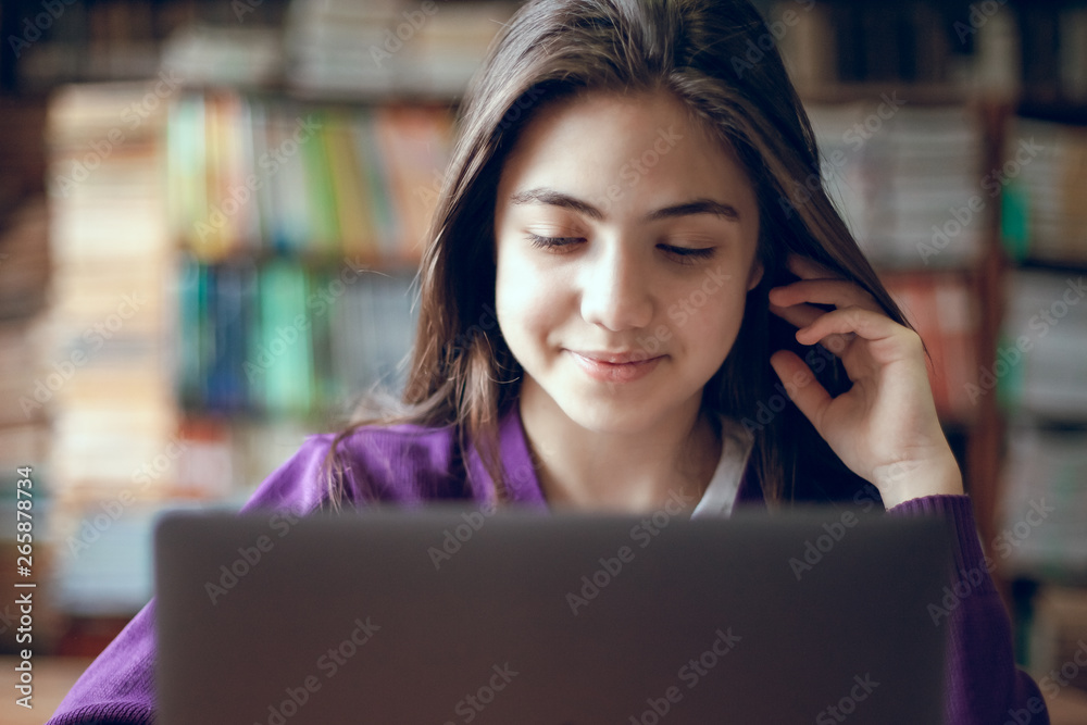 pretty school girl studying in the school library using laptop Stock ...