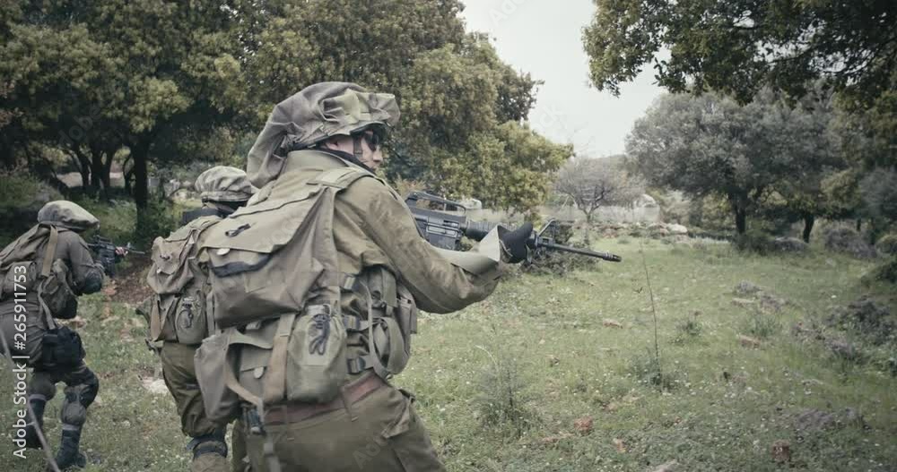 Squad of fully armed commando soldiers during combat in a forest ...