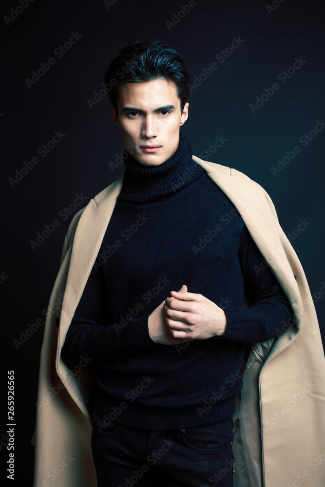 handsome asian fashion looking man posing in studio on black background ...