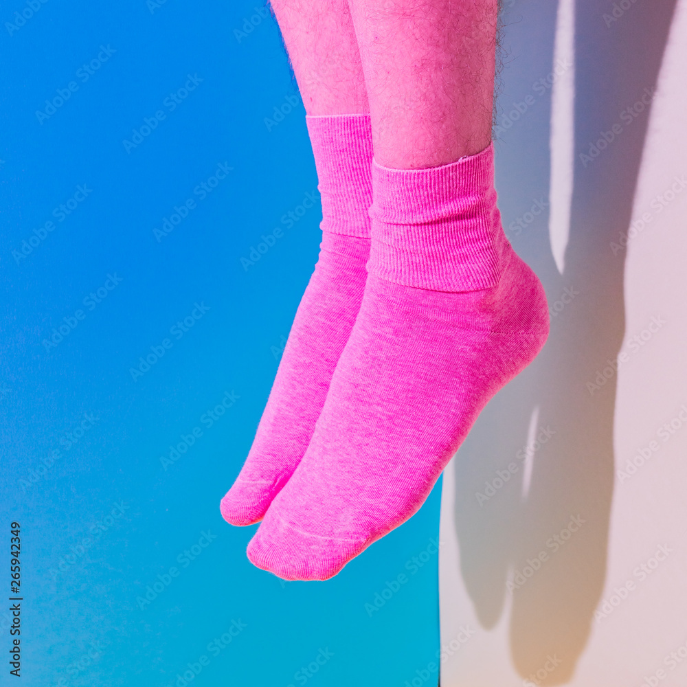 Alien male feet with pink hairy skin in socks flying in the air above ...