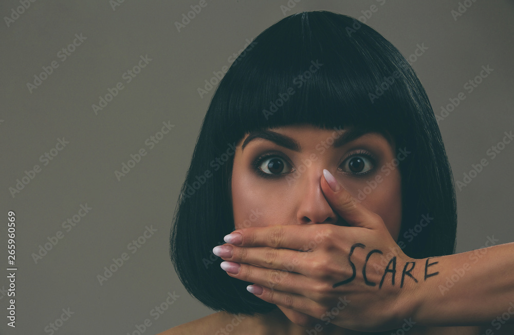 Young scared woman with black hair posing on camera. Scared afraid ...