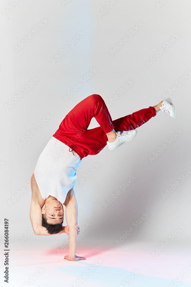 Free style dancer in red sports trousers doing some acrobatic stunts ...