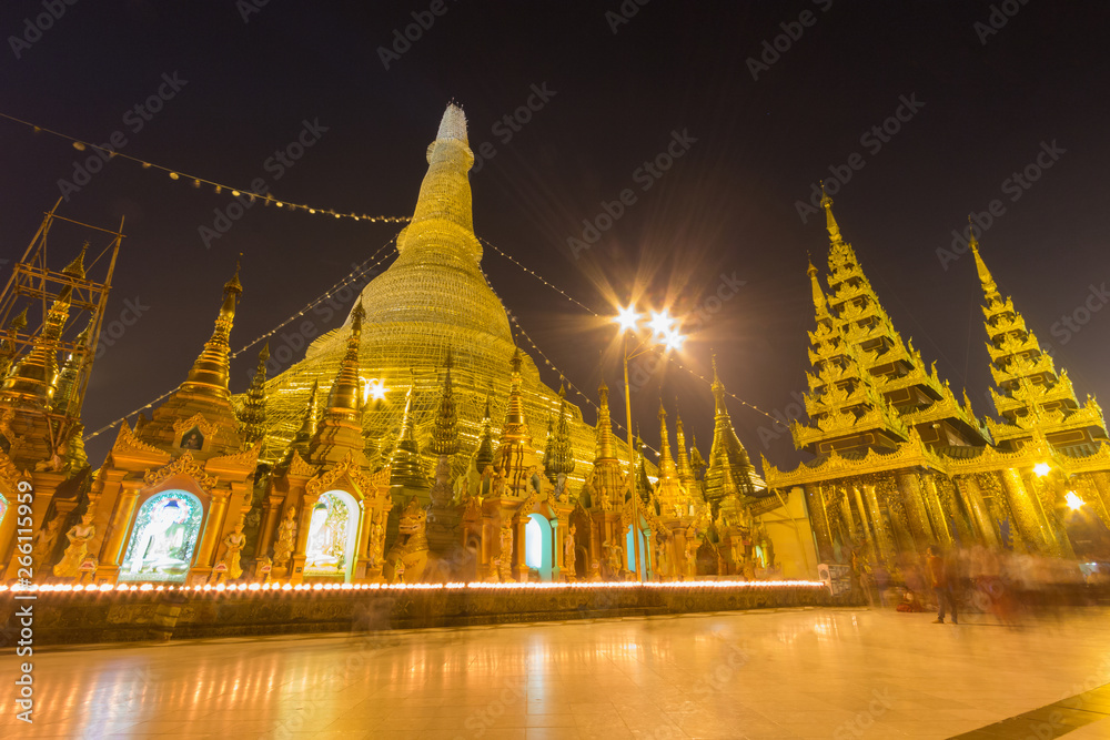 Shwedagon pagoda at Yangon in Myanmar at night time with people motion ...