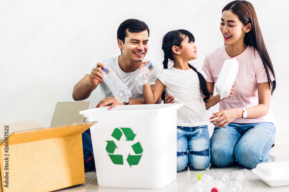 Happy smiling family having fun putting empty recycling plastic bottles ...