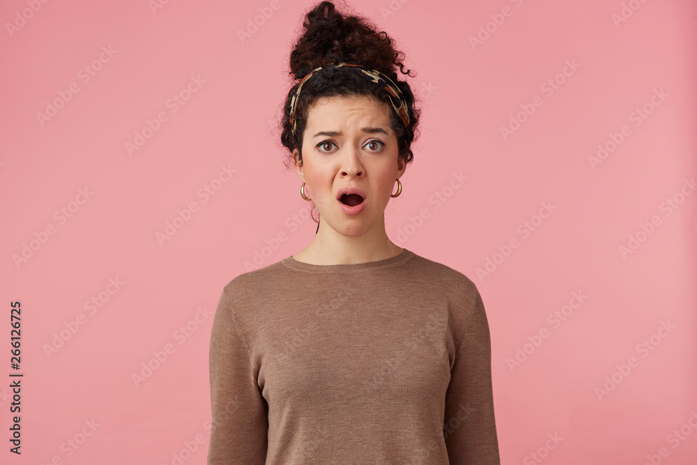 Shocked young beautiful woman with curly dark hair, with wide open ...