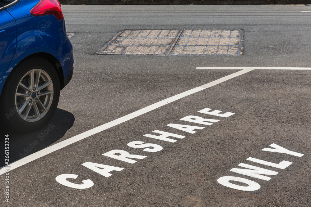 Carshare only road sign on inner city asphalt parking space. Stock ...