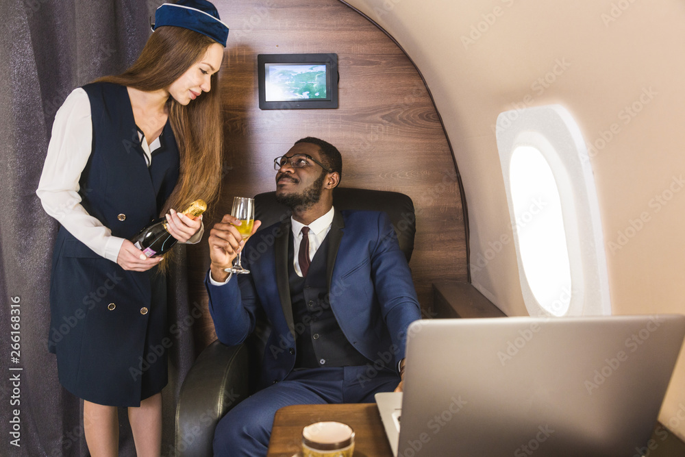 Young successful Afro-American businessman in glasses and a stewardess ...