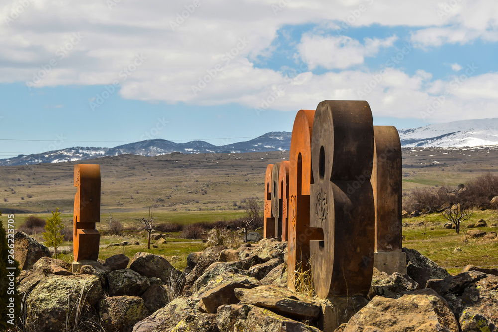 monument statue alphabet letters made of stone standing on the rocks on ...