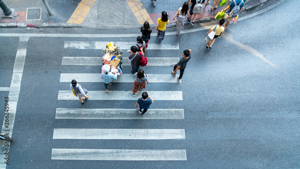 people are moving across the pedestrian crosswalk in the city road (on ...
