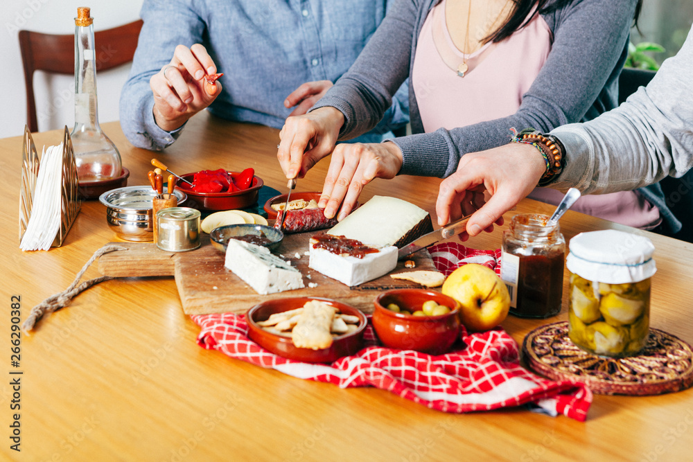 hands cutting and picking up food from a laid table. celebrations ...
