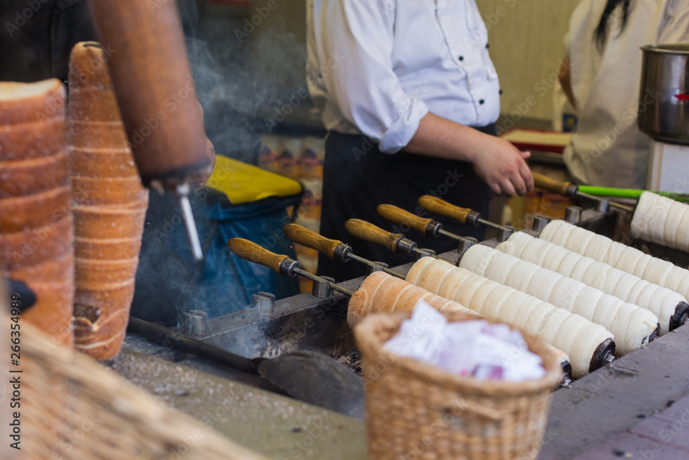 Making Trdelnik or Trdlo or Kurtosh Kalach being baked in a street ...
