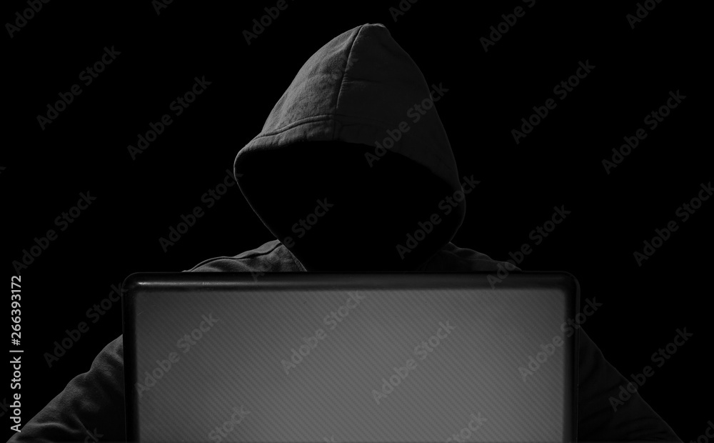 hacker with glowing mask behind notebook laptop in front of isolated ...
