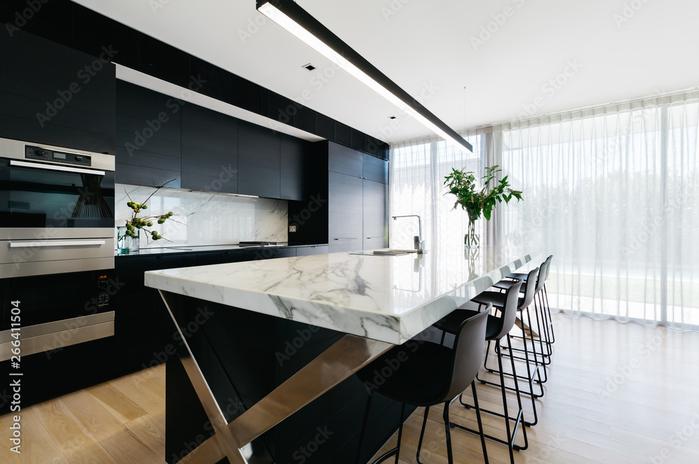 Luxury open plan black kitchen with calcutta marble benchtop Stock ...