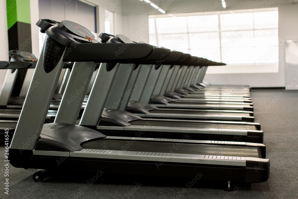 Gym apparatus in a gym hall. Treadmills set in gym interior. Fitness ...