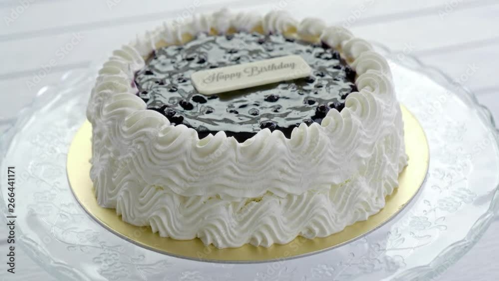 3/4 angle footage of slowly rotating white-red birthday cake with ...