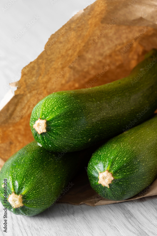 Foto de Organic courgette in a brown paper bag on grey wood. Recycle ...