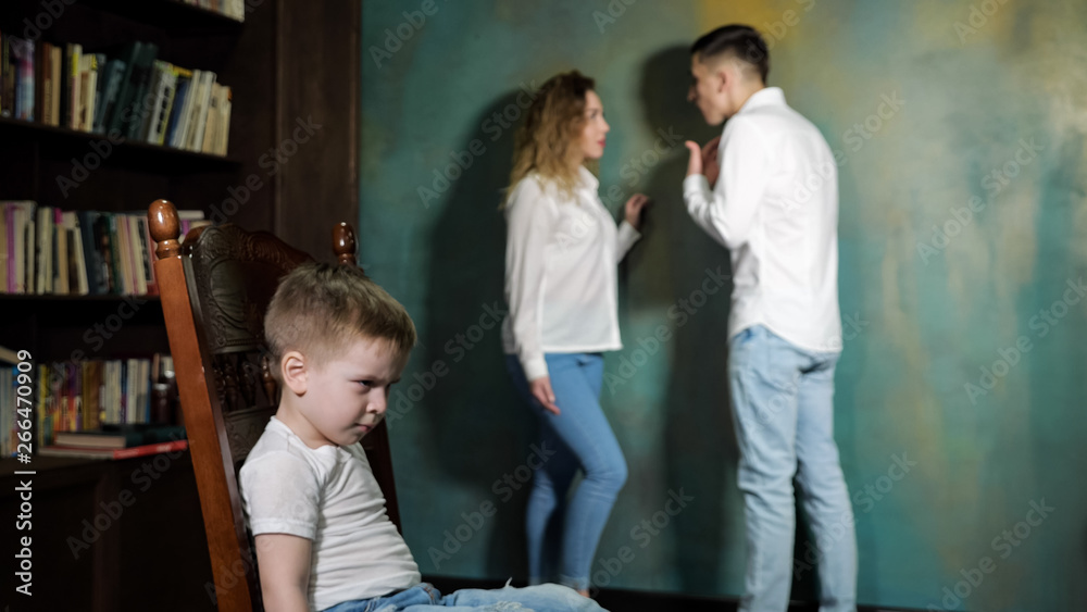 Couple of parents arguing in front of their kid. Sad little boy is ...