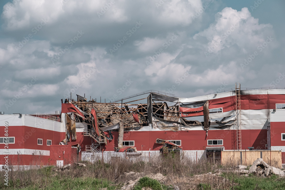 Ruined and demolished industrial building after fire with broken roof ...