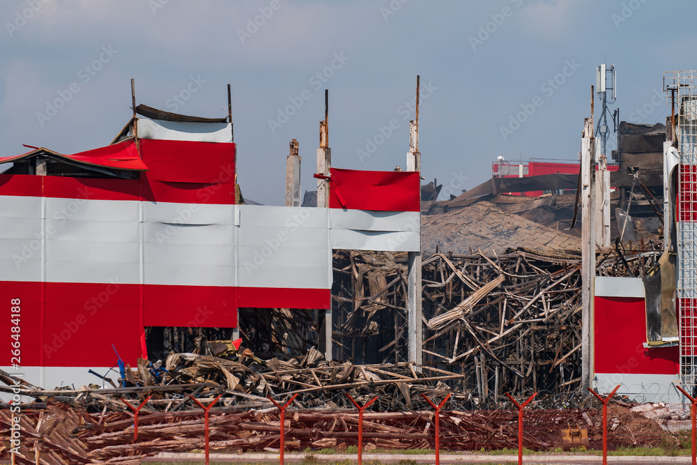 Ruined and demolished industrial building after fire with broken roof ...