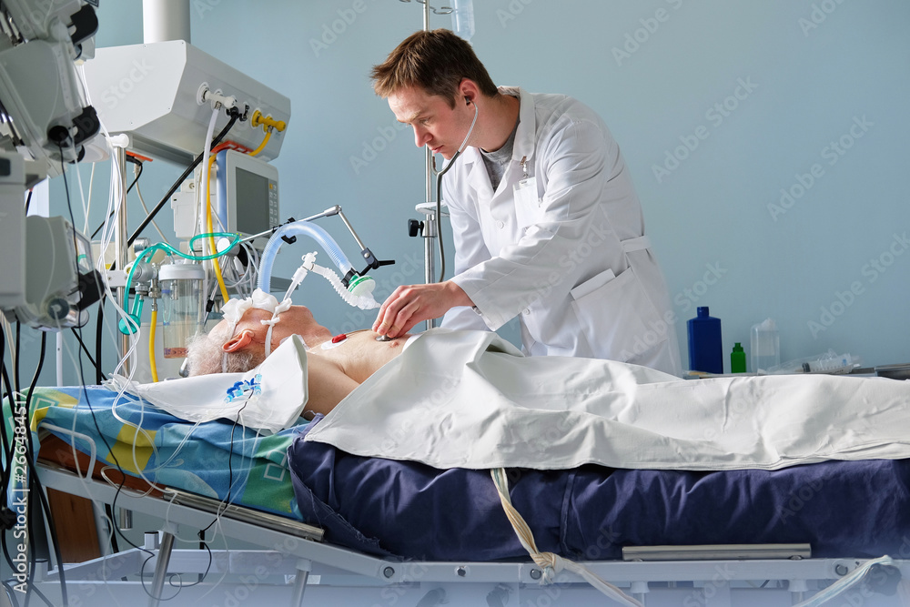 Intensive care caucasian doctor examines intubated critical stance ...