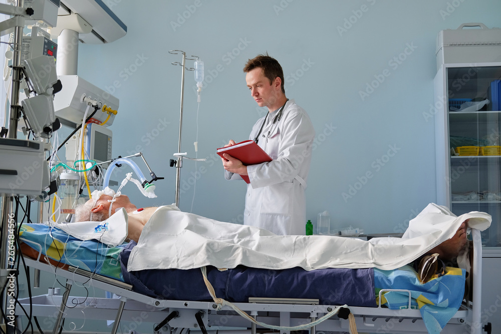 Intensive care caucasian doctor examines intubated critical stance ...
