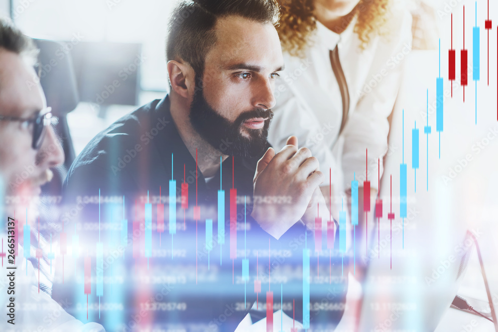 Team of crypro stock traiders sitting front of computer with technical ...