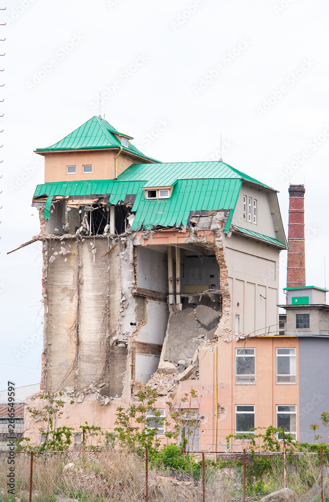 View on a partially collapsed brick industrial building with green ...