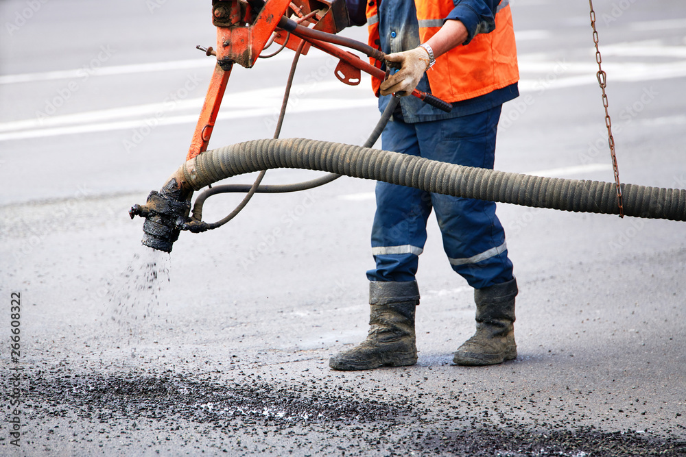 Professional worker in uniform during fast repair road surface ...
