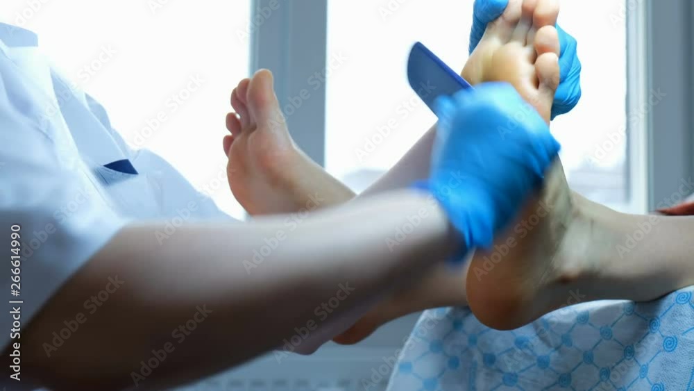 Pedicure master cleans the old layer of skin from feet with a foot ...