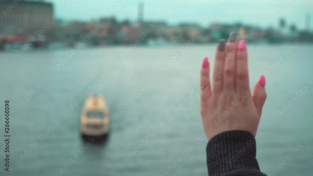Woman waving hand at the departing ship. The ship goes along the river ...