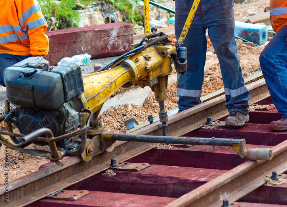 Railway workers bolting track rail. Detail worker with mechanical ...