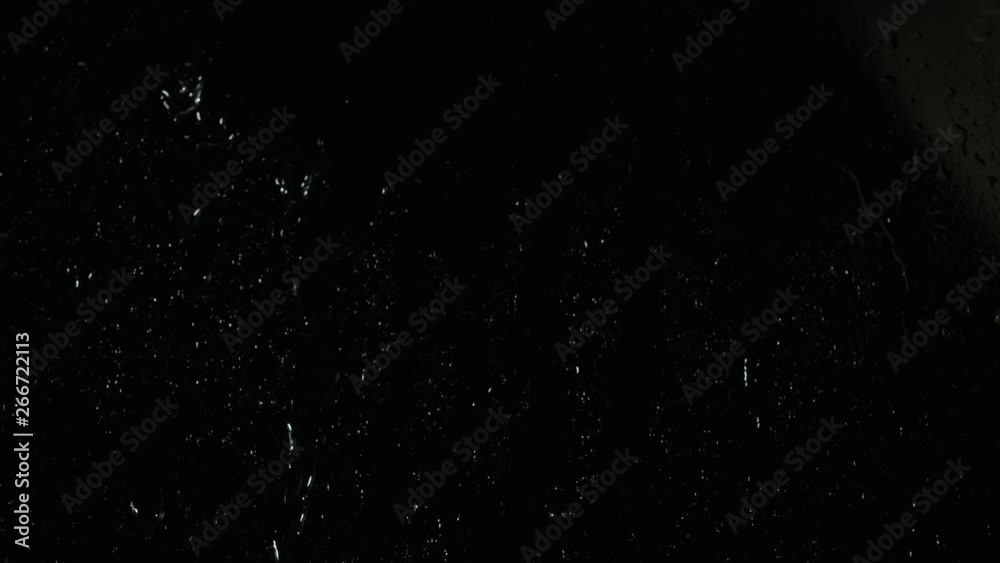 Transparent water drops flowing down the glass and small white ...