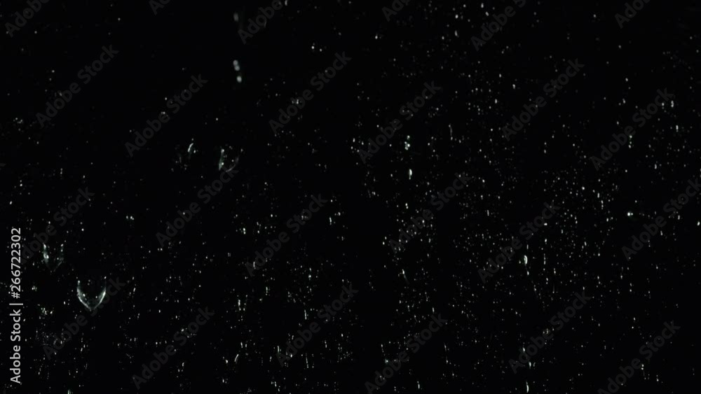 Transparent water drops flowing down the glass and small white ...