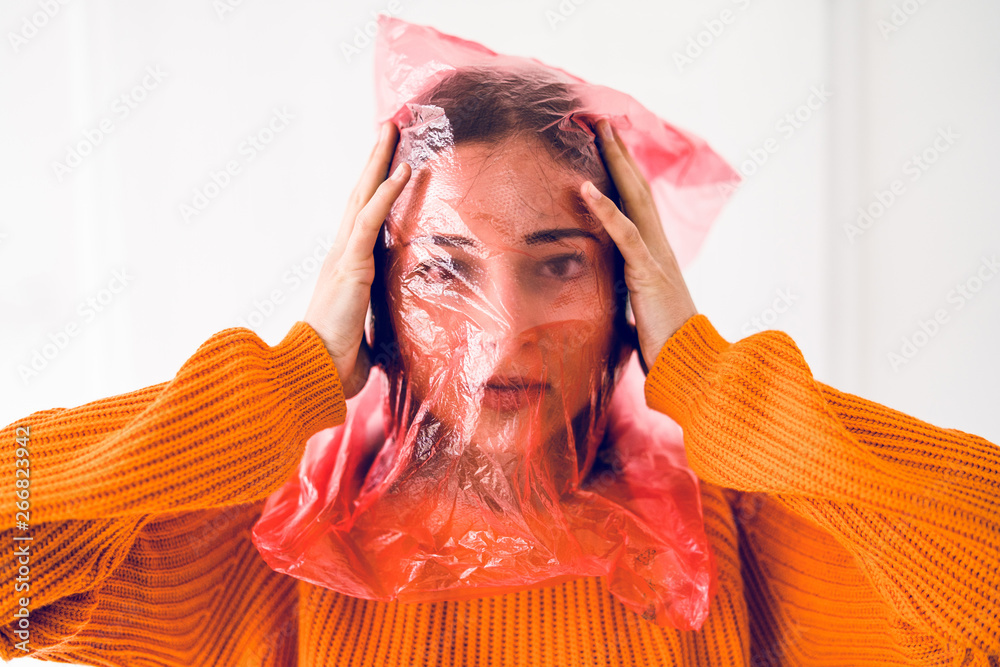 Young woman with plastic bag on her head choking, antipollution save ...