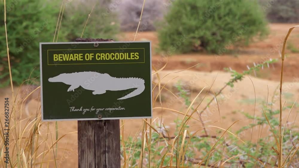 A sign warns tourists to Beware of Crocodiles. Stock ビデオ | Adobe Stock