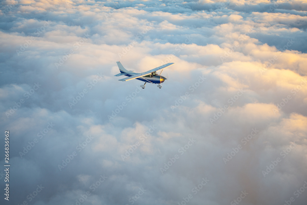 Small single engine airplane flying in the gorgeous sunset sky through ...