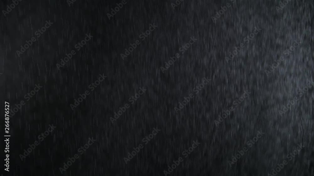 4k Heavy angled rain falling in front of the camera against black ...